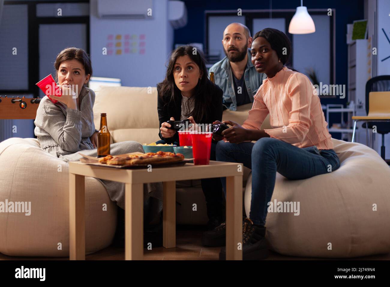 Diverse group of coworkers having fun with video games on console ...