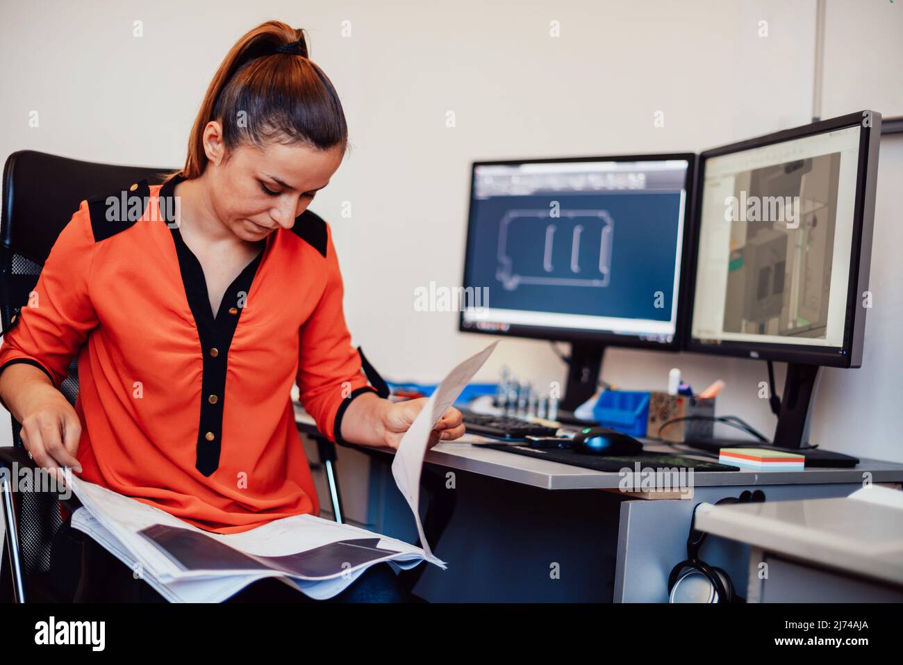 Within the heavy industry, a factory industrial engineer measures with ...