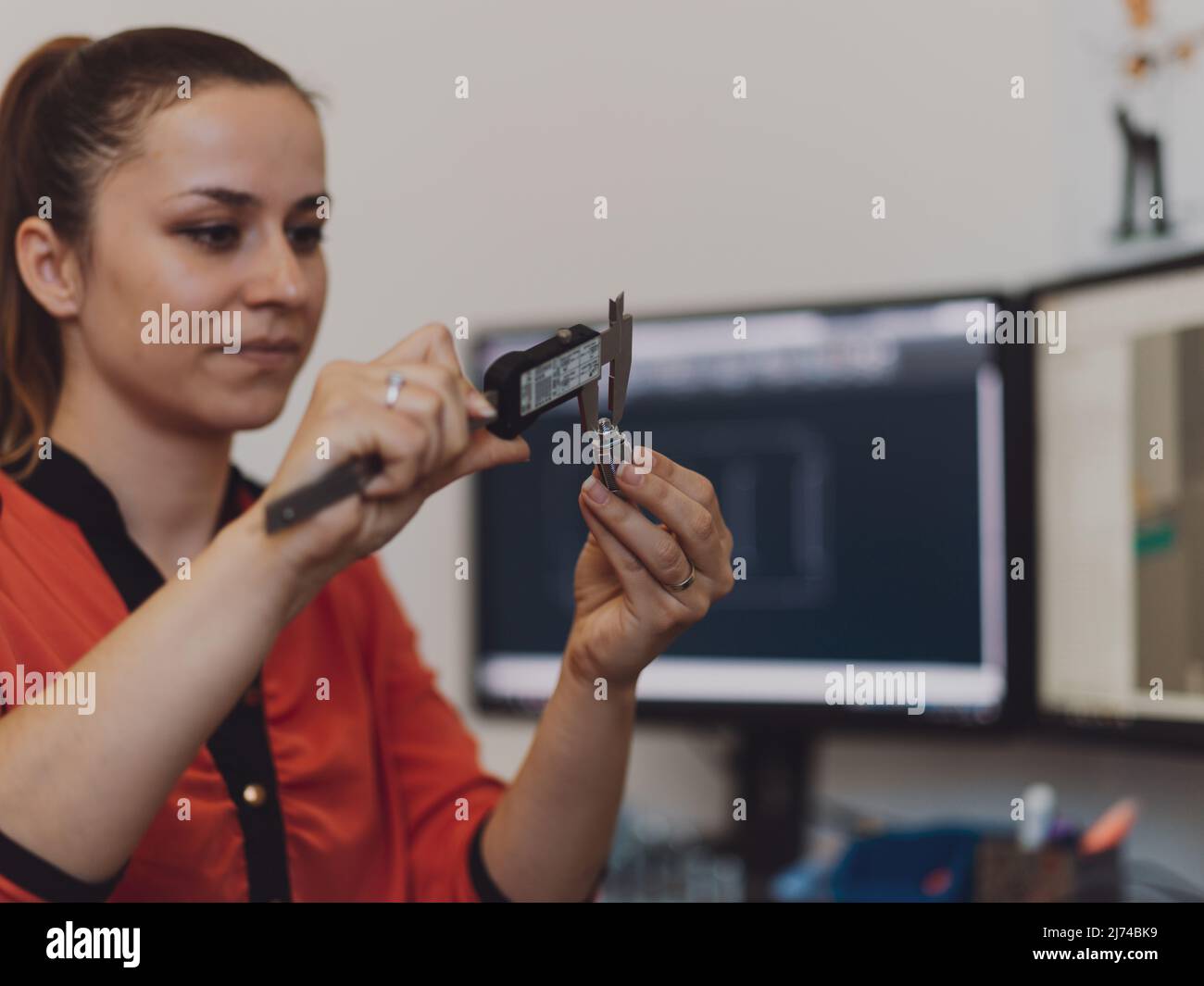 Within the heavy industry, a factory industrial engineer measures with a caliper and on a ...