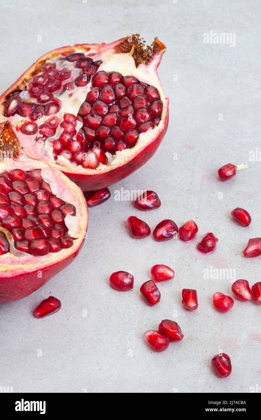 Pomegranate split open with pips on a grunge surface with copy space ...