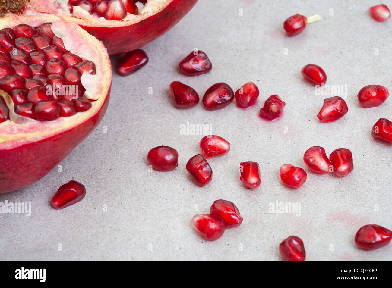 Pomegranate split open with pips on a grunge surface with copy space ...