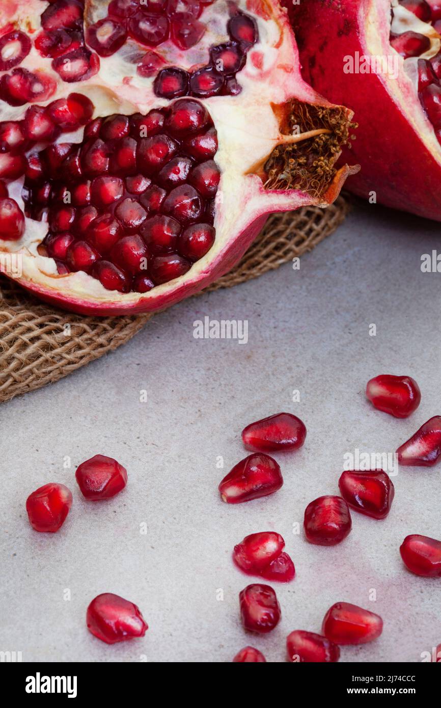 Pomegranate split open with pips on a grunge surface with copy space ...