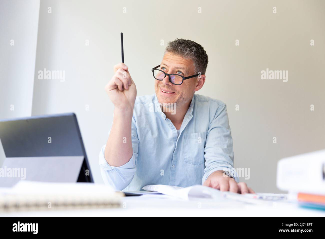Business portrait of architect sitting at his work table and planning ...
