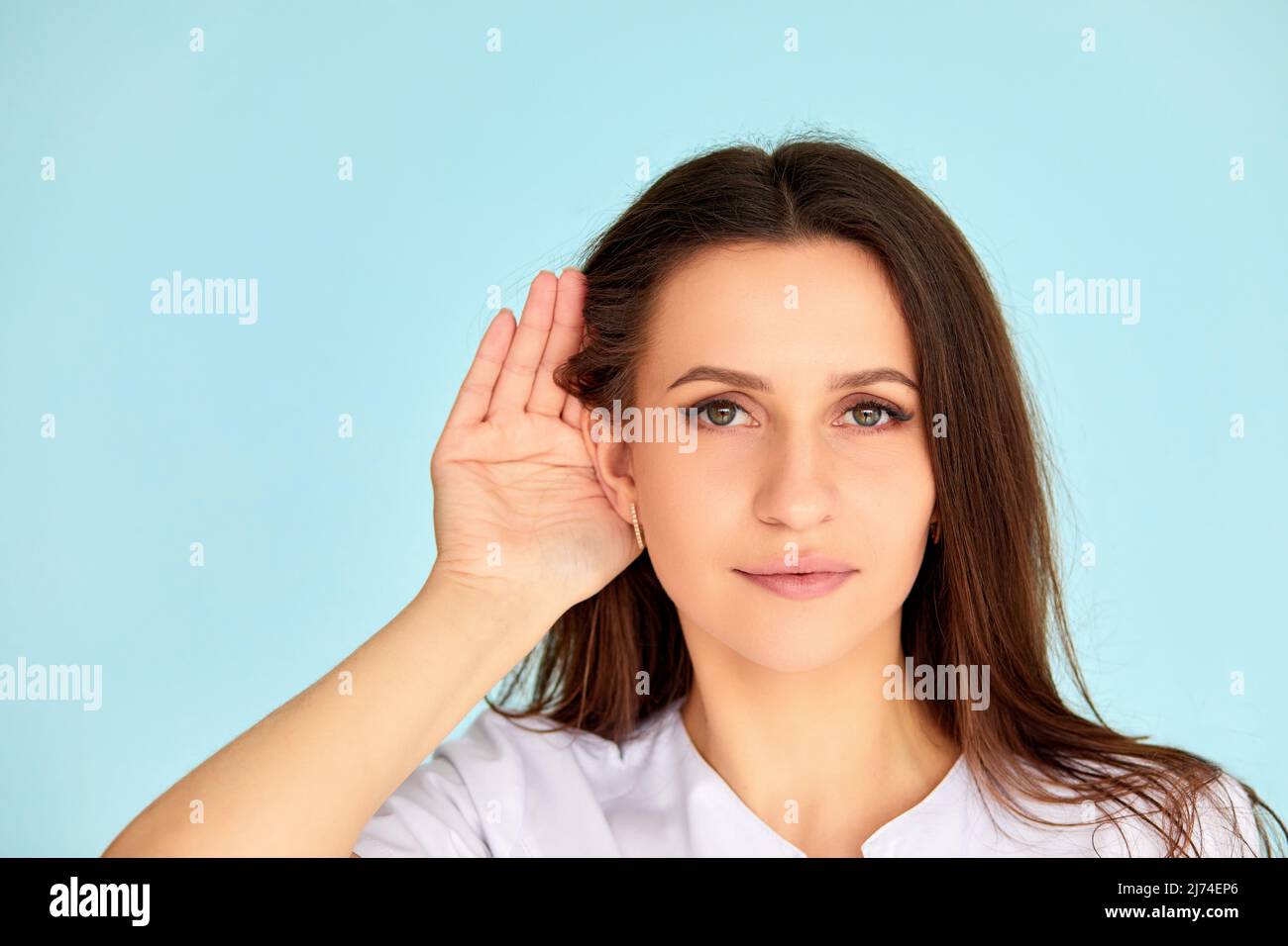 Woman holds her hand near ear and listens carefully Stock Photo - Alamy