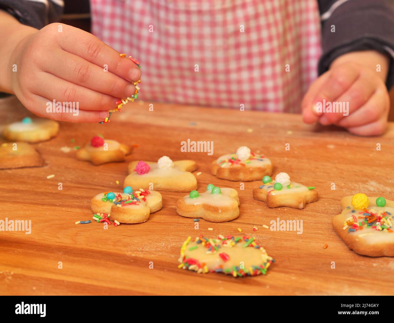 photo shows a kids hand decorating butter cookies with sprinkles Stock ...