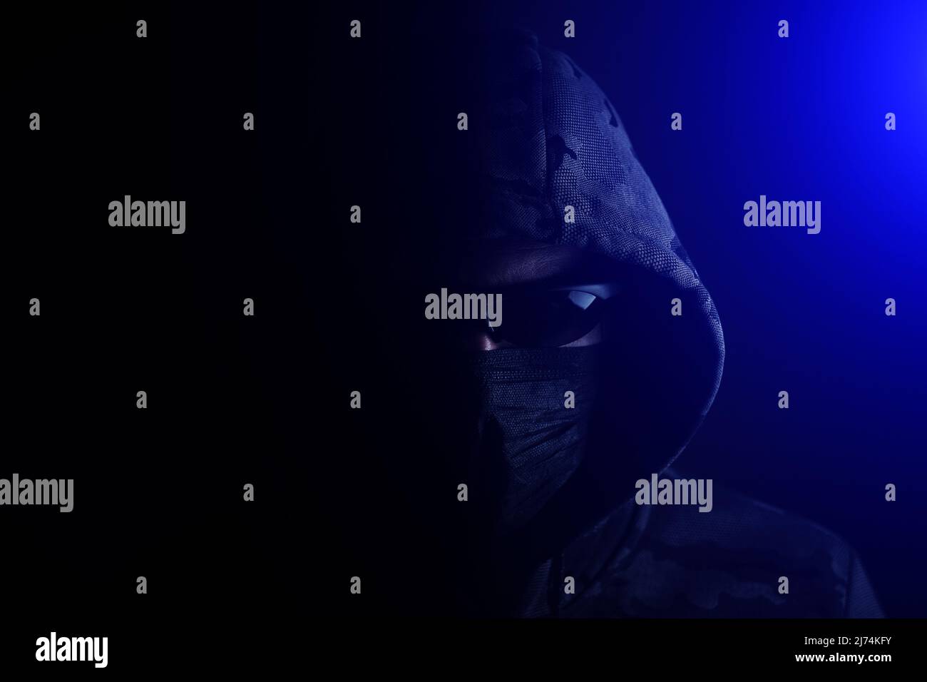 Stylish man in dark hoodie, black glasses and mask dark background in ...