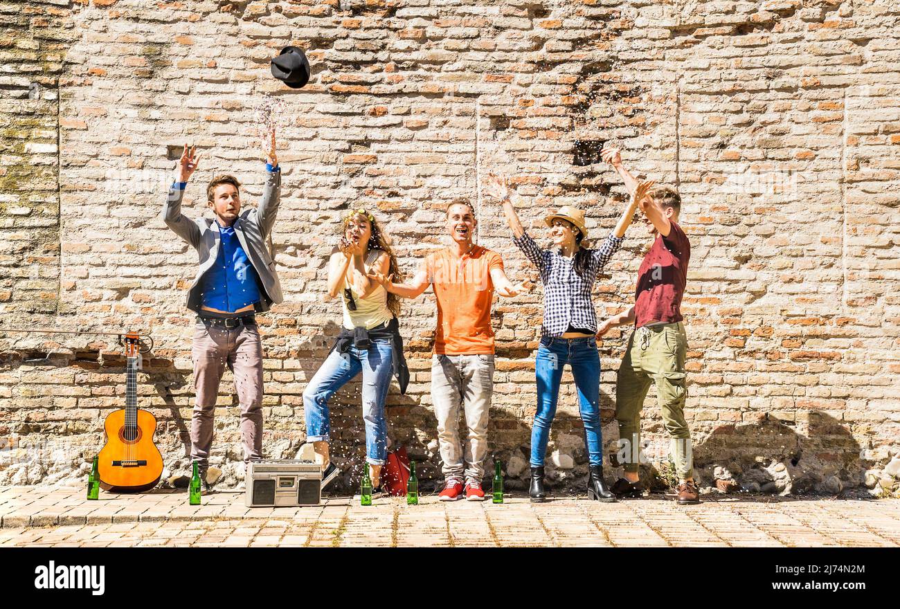 Happy friends group having fun outdoor cheering with confetti and beer ...