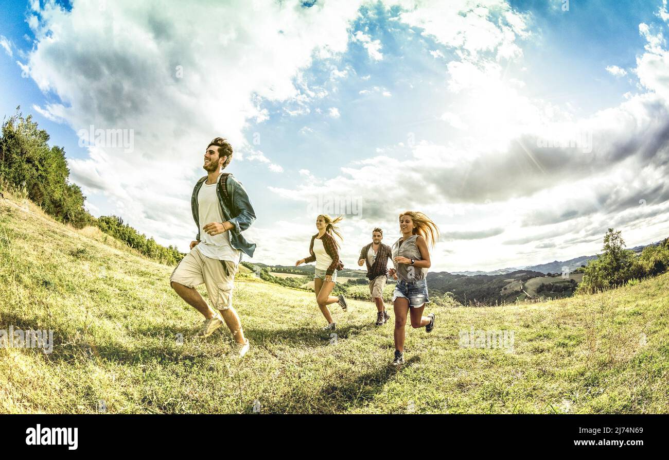 Group of friends running free on grass meadow - Friendship and freedom ...