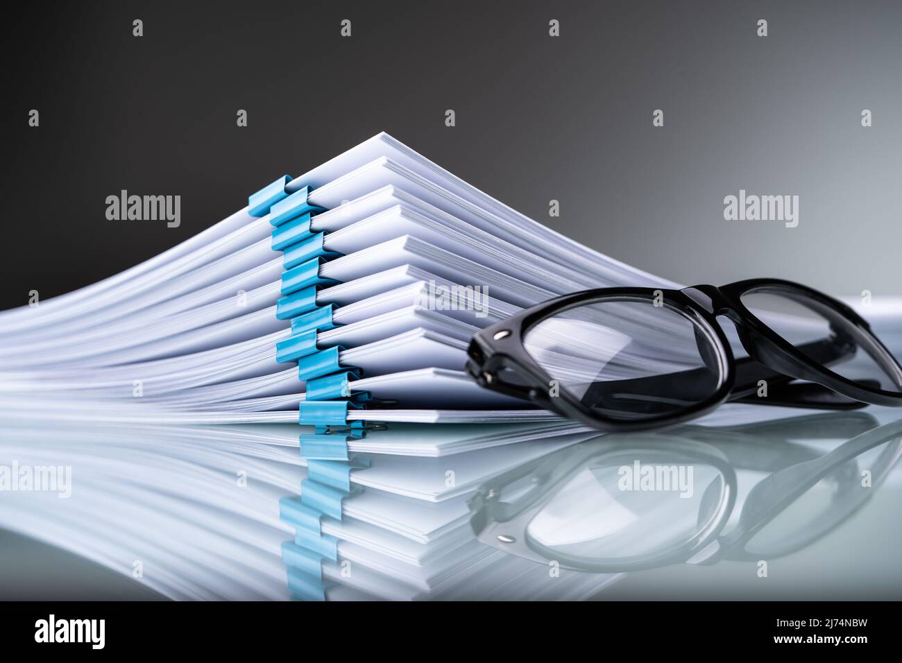 Stacked Documents With Blue Paperclips And Eyeglasses Stock Photo - Alamy
