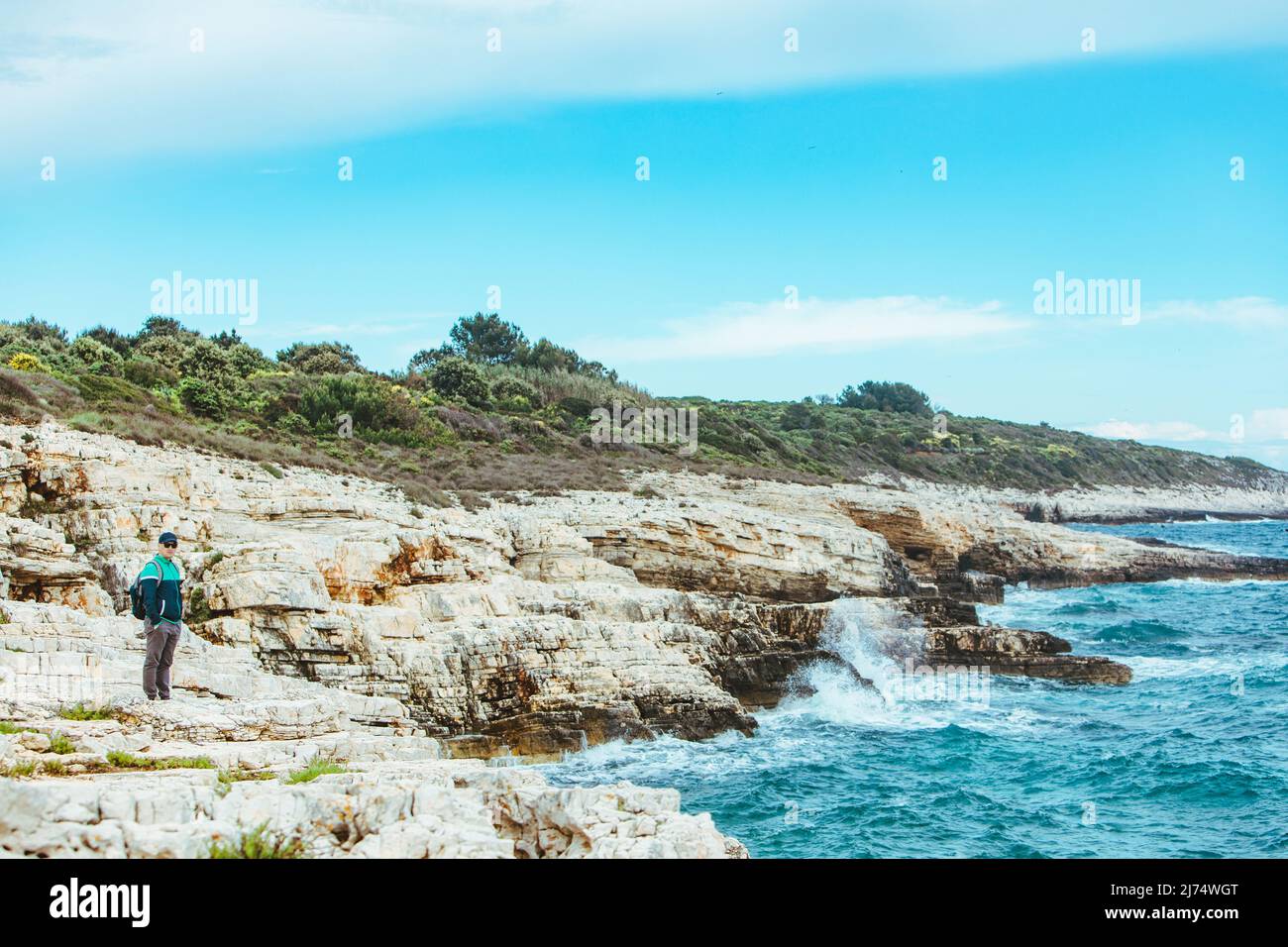 man climbing. rocky edge. enjoying seascape view. travel concept Stock ...
