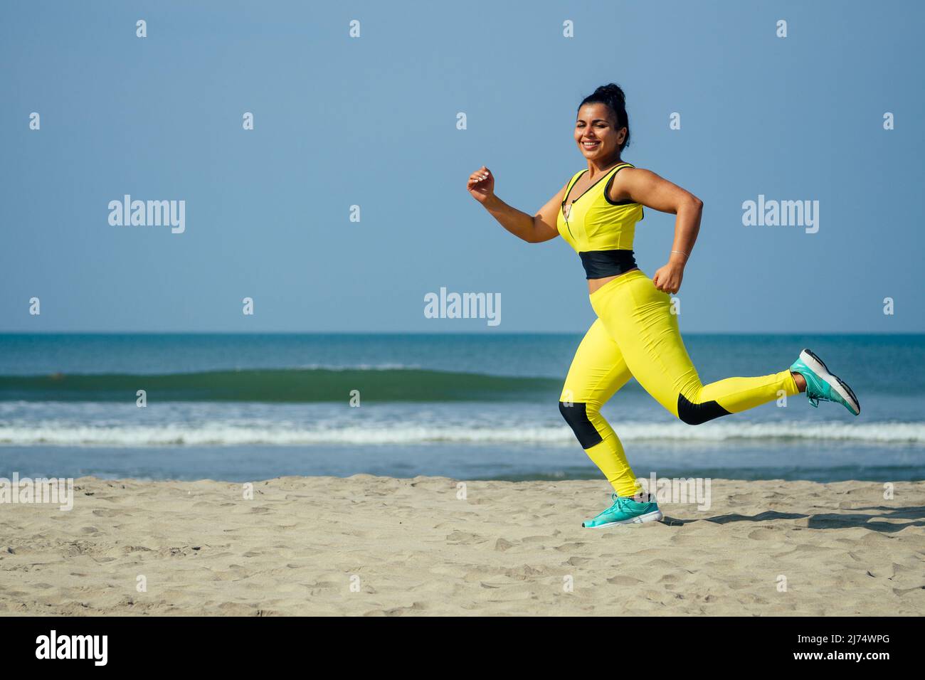 Female runner jogging during outdoor workout on beach. Beautiful fit ...