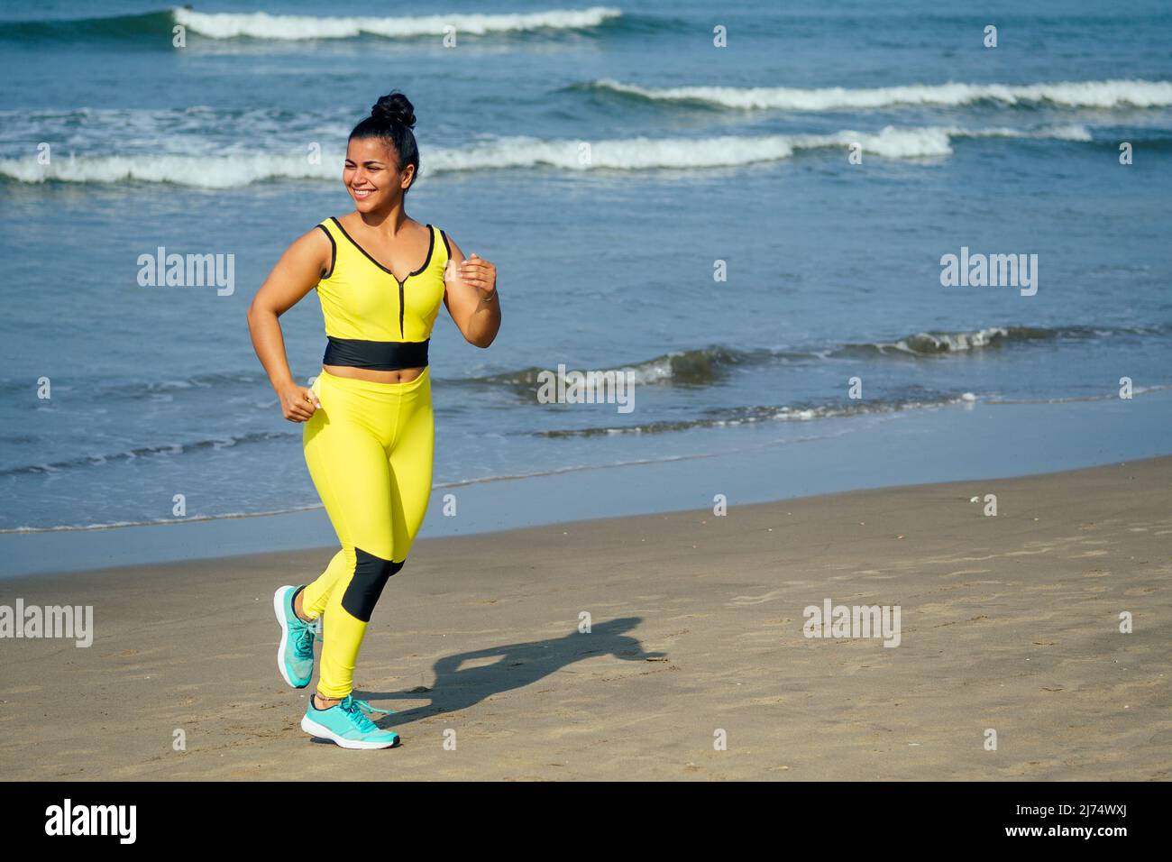 Female runner jogging during outdoor workout on beach. Beautiful fit ...