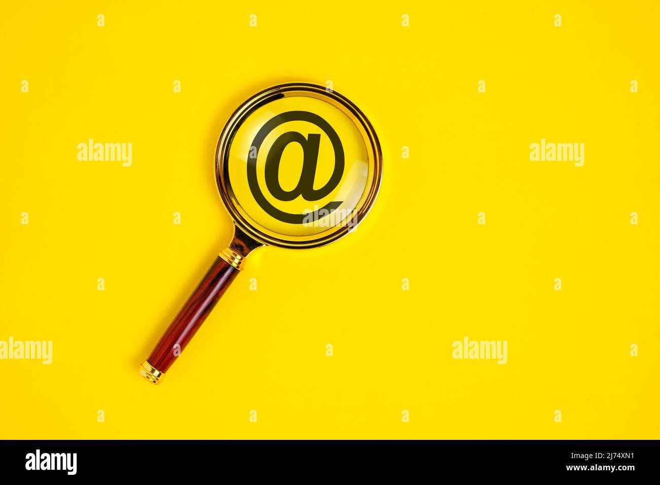 Dog sign is an email symbol under magnifying glass on yellow background ...