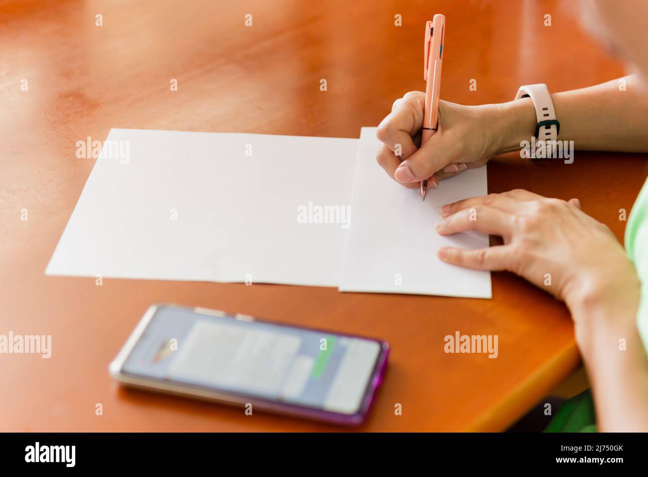 Woman with pen writing address on envelope Stock Photo - Alamy