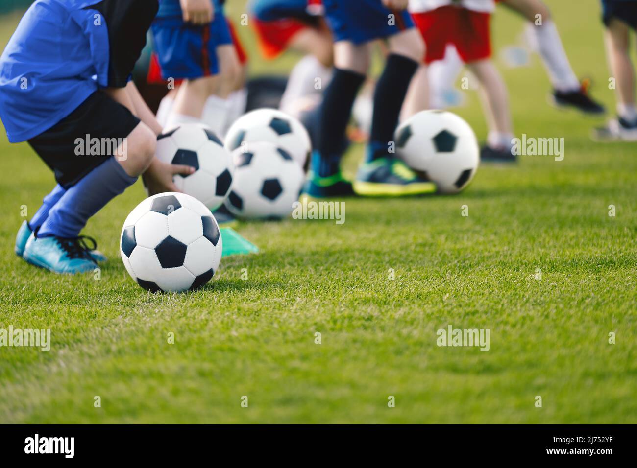 Group of school children running and kicking soccer balls on summer ...