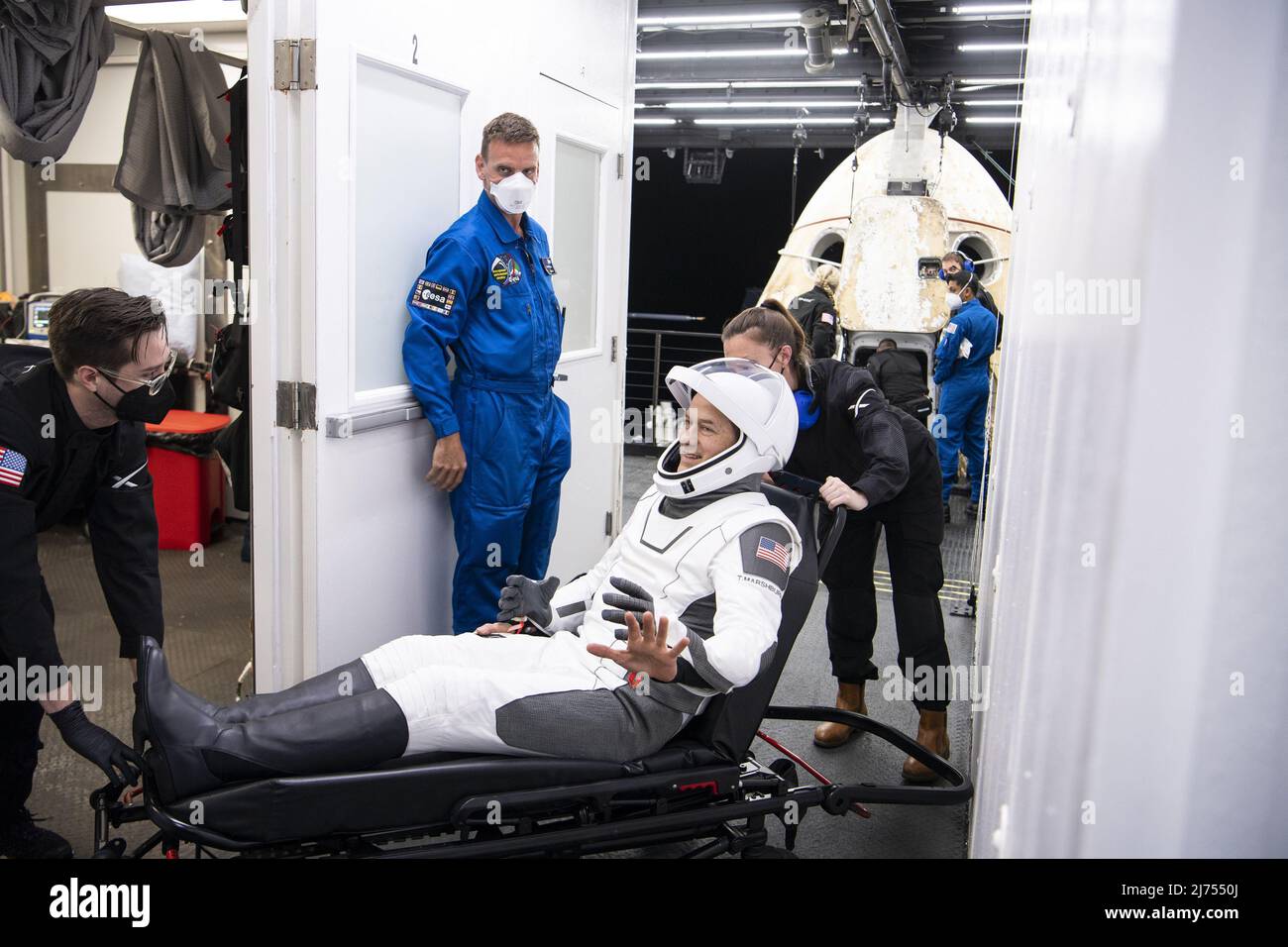 NASA astronaut Tom Marshburn greets friends after being helped out of the SpaceX Crew Dragon ...