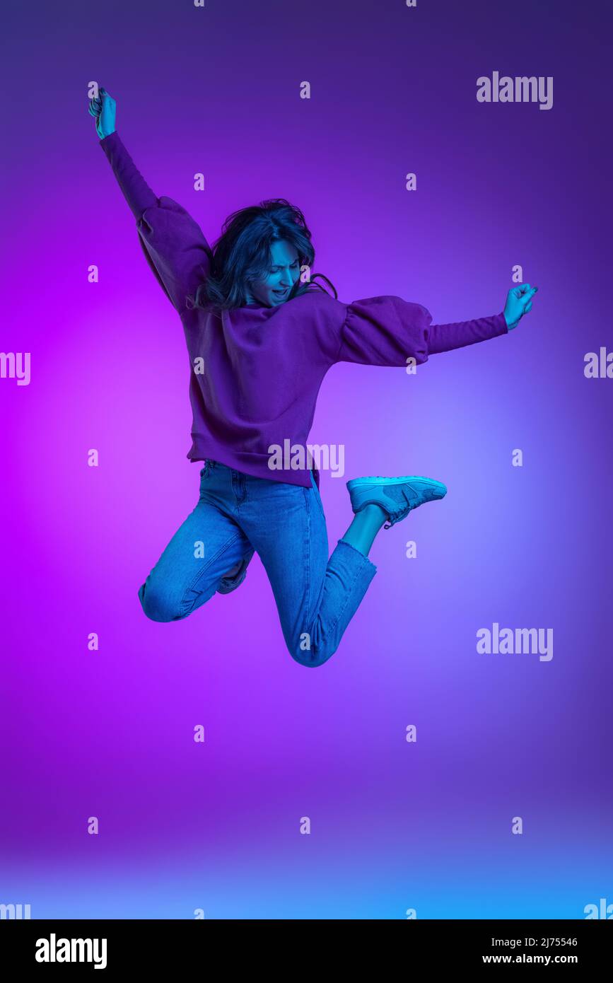Full-length portrait of young excited girl, student jumping isolated ...