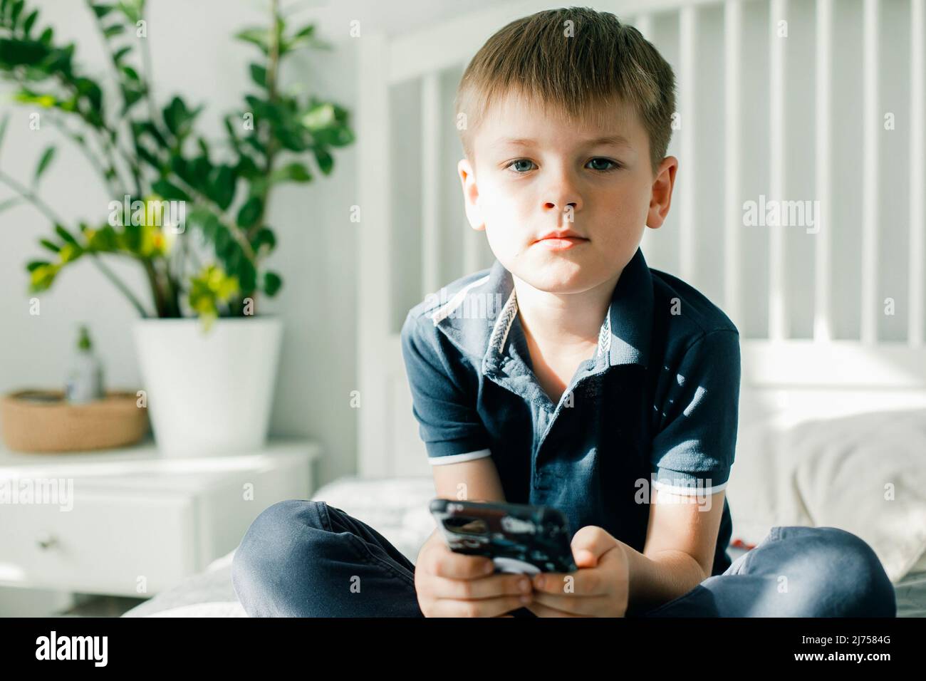 Child school boy holding phone, using cell phone for chatting with ...