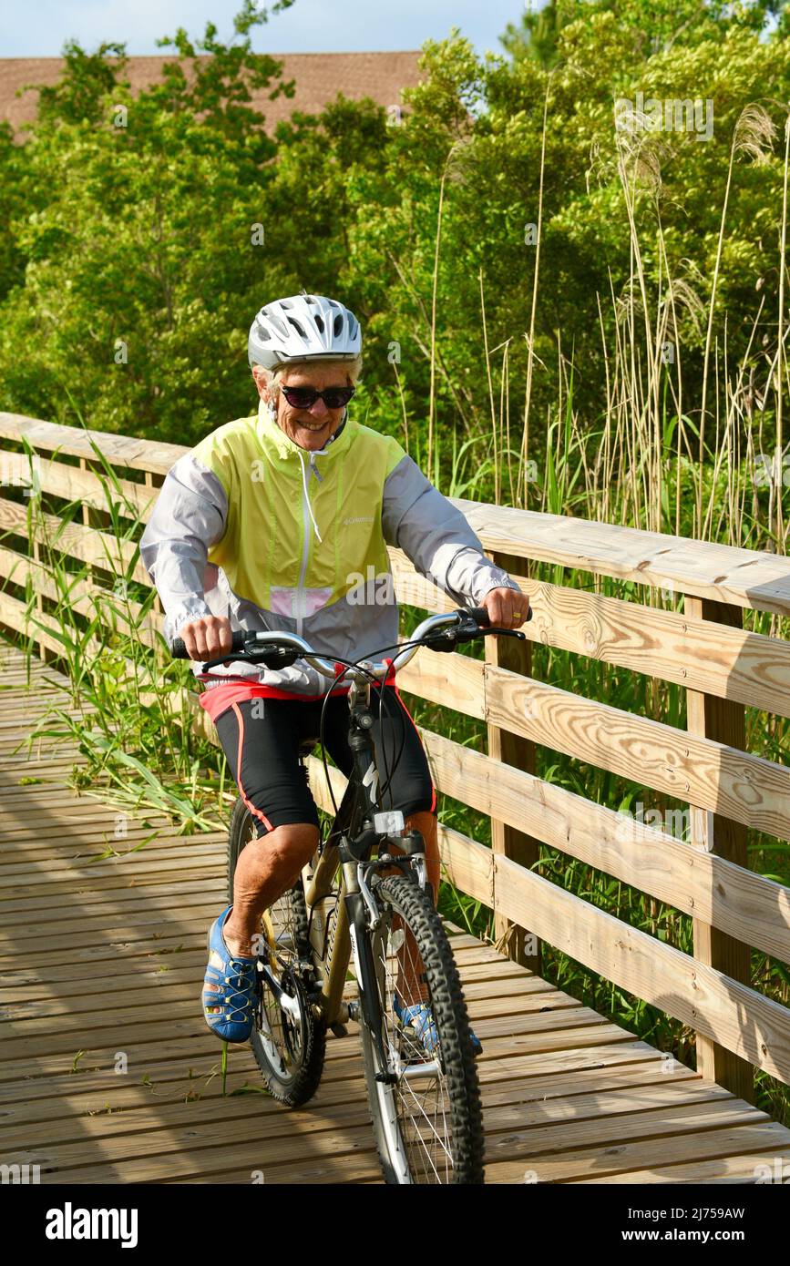 Middle age woman pedaling a bicycle on scenic trails and pathways in ...