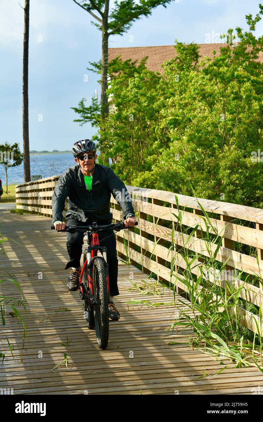 Middle aged, senior man pedaling a bicycle on scenic trails and ...
