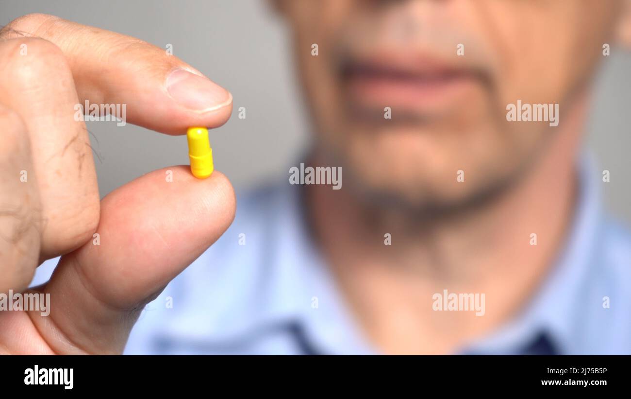 The older man eats the pill Stock Photo - Alamy