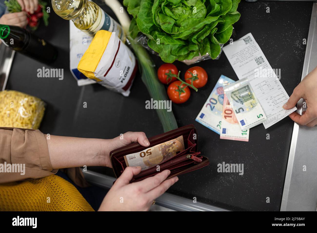 Close-up of woman giving money at the cash desk in supermarket Stock ...