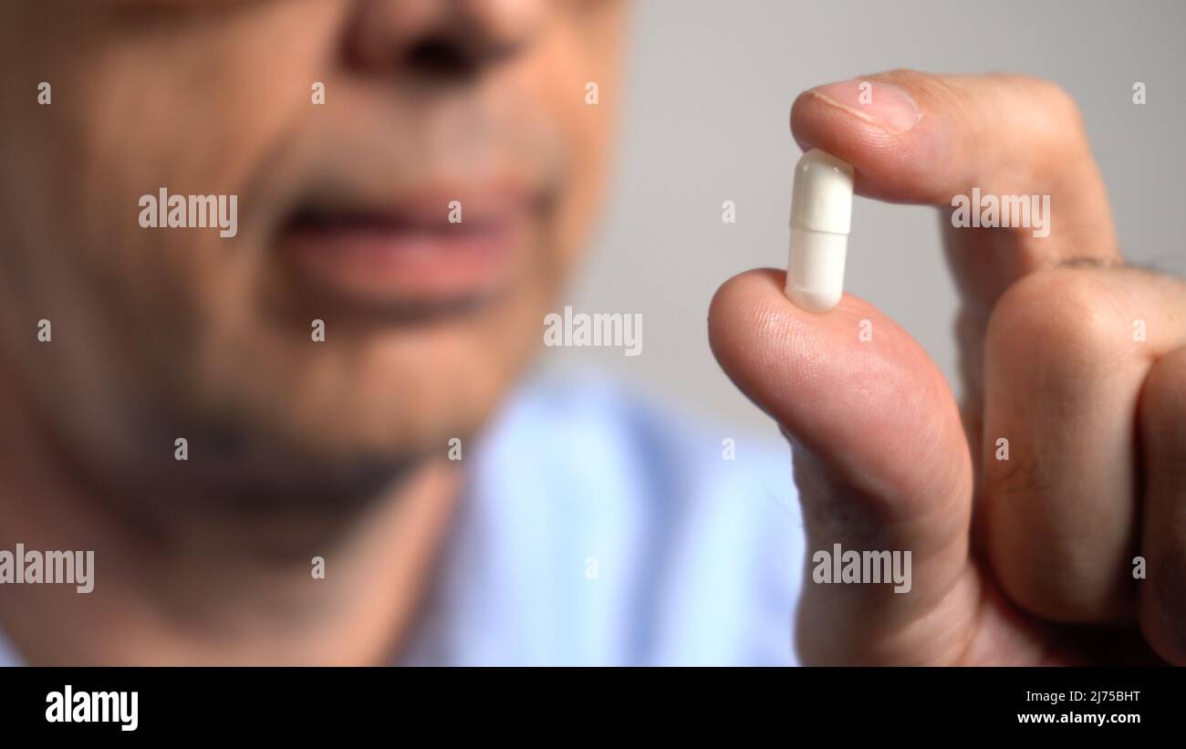 The older man eats the pill Stock Photo - Alamy