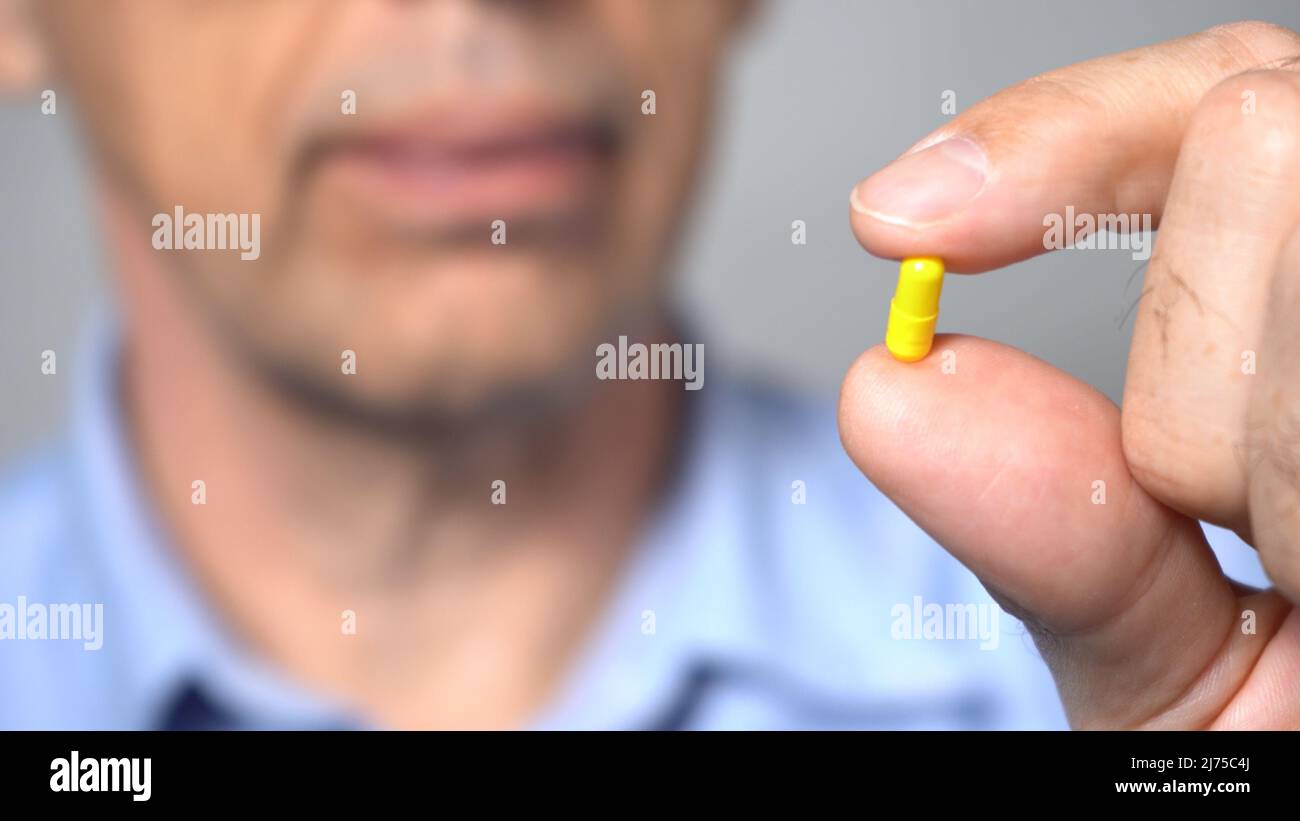 The older man eats the pill Stock Photo - Alamy