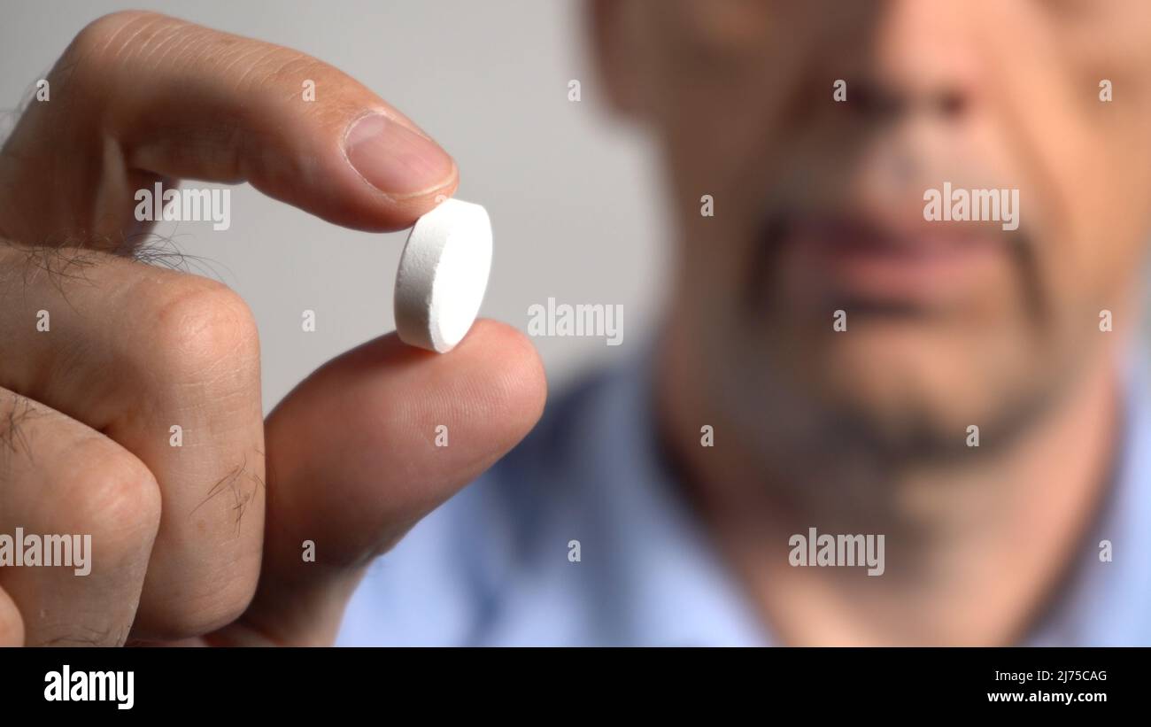 The older man eats the pill Stock Photo - Alamy