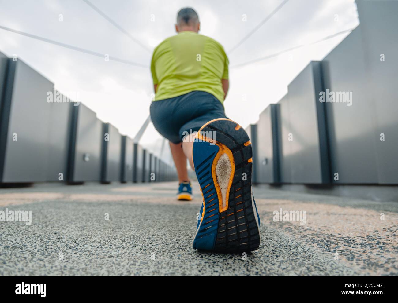 Older man in good shape warming up before running outdoors Stock Photo ...