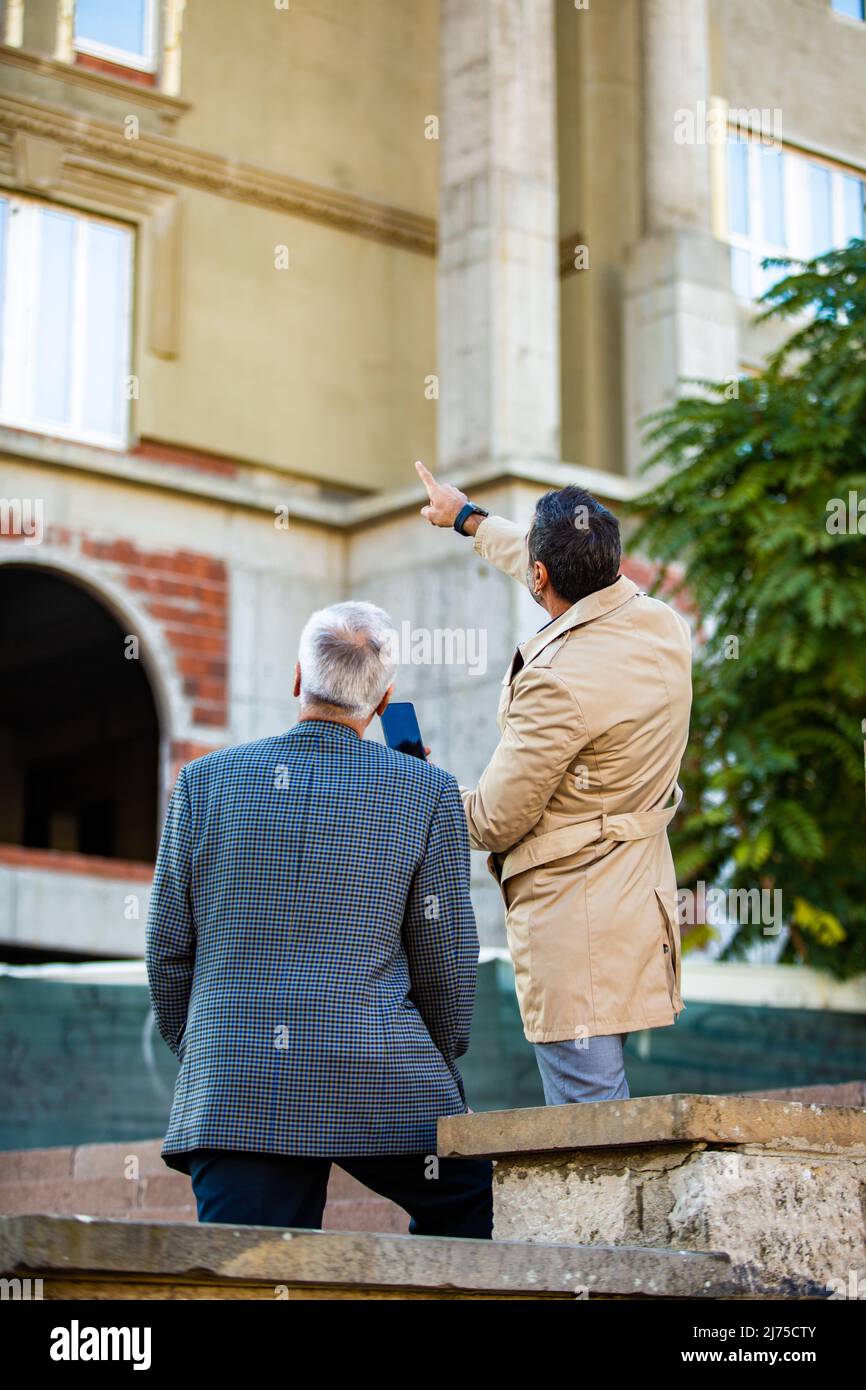 Amazing and handsome businessman is explaining the building to his boss ...