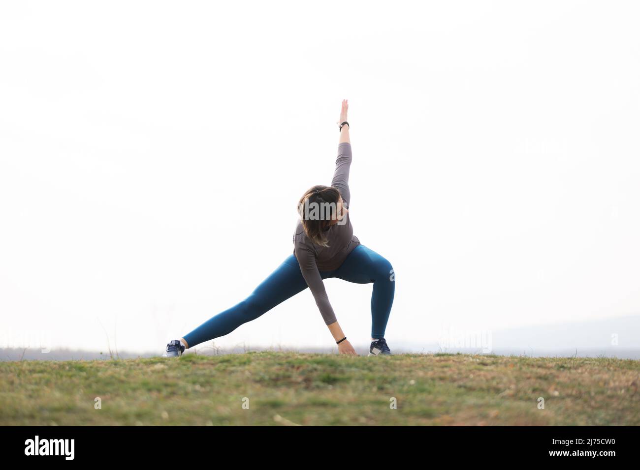 Amazing and active woman is stretching alone before the training Stock ...