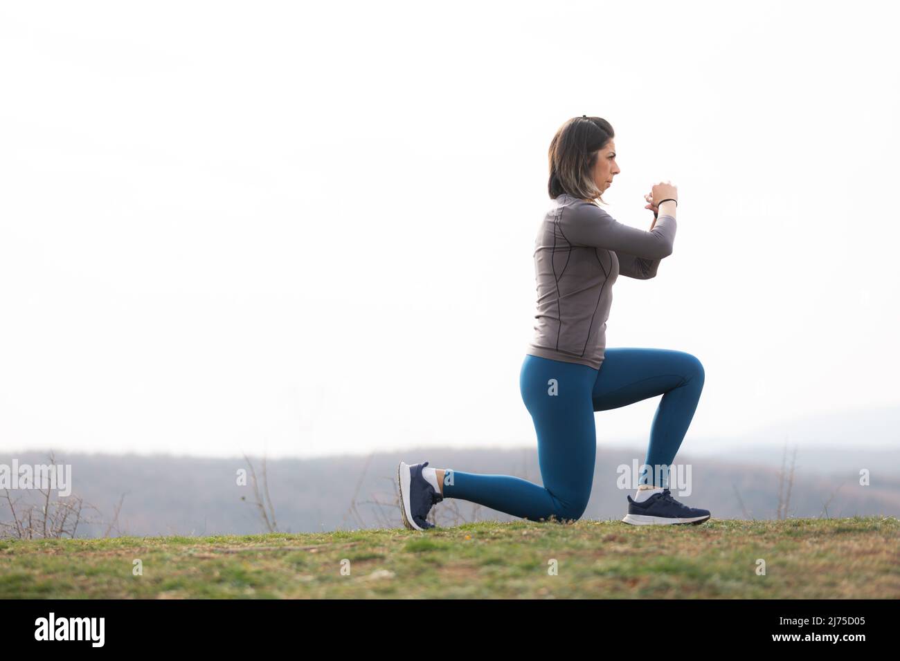 Amazing and active woman is doing some side squats exercise Stock Photo ...