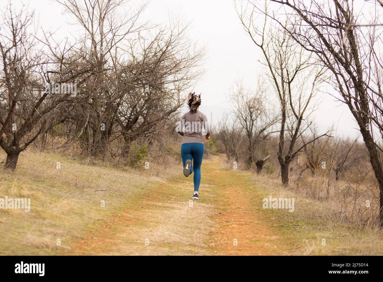 Middle aged woman running in nature Stock Photo - Alamy