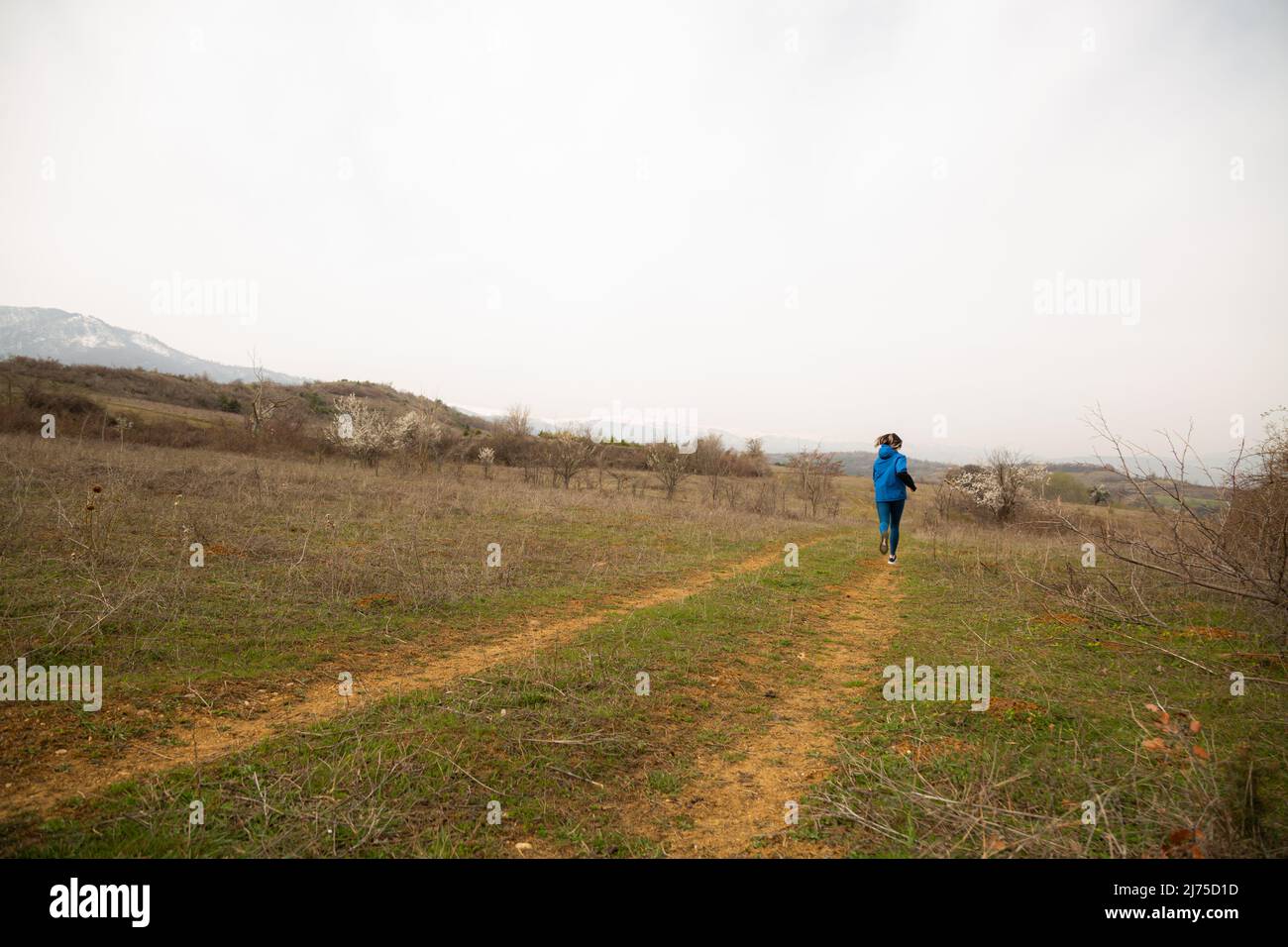 Girl from the back in nature running Stock Photo - Alamy