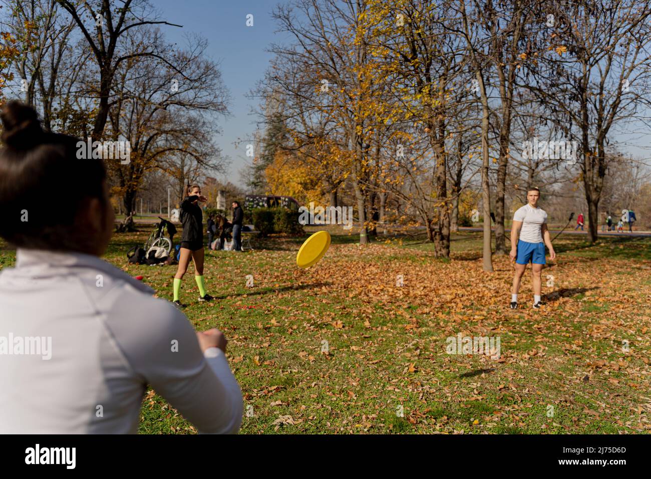Two attractive and amazing fit friends are playing frisbee outside ...