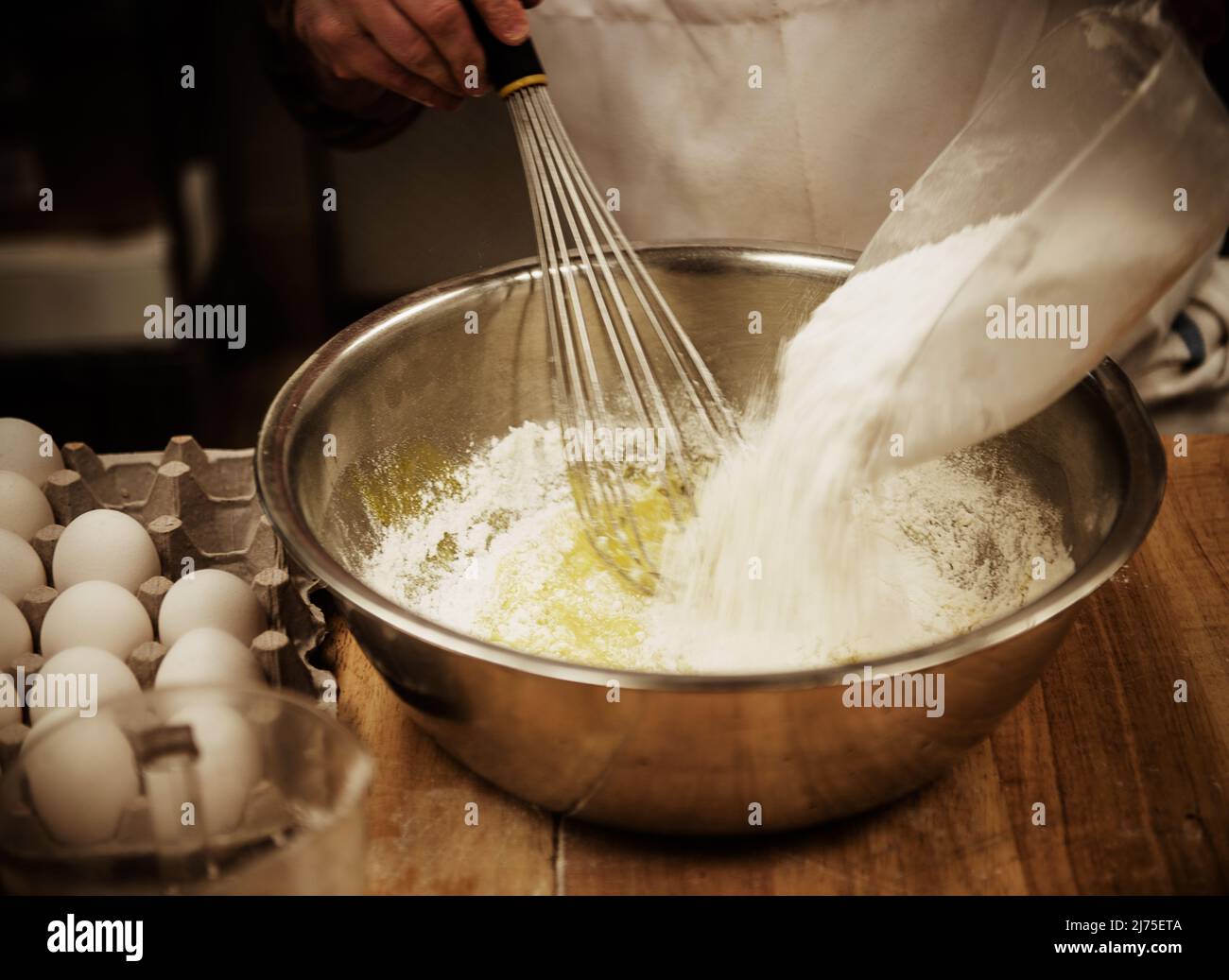 Baker mixing flour and eggs in a bakery Stock Photo - Alamy