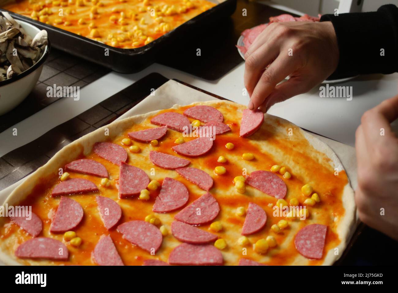 Man cooking homemade pizza on a wooden table in a home kitchen. Male ...