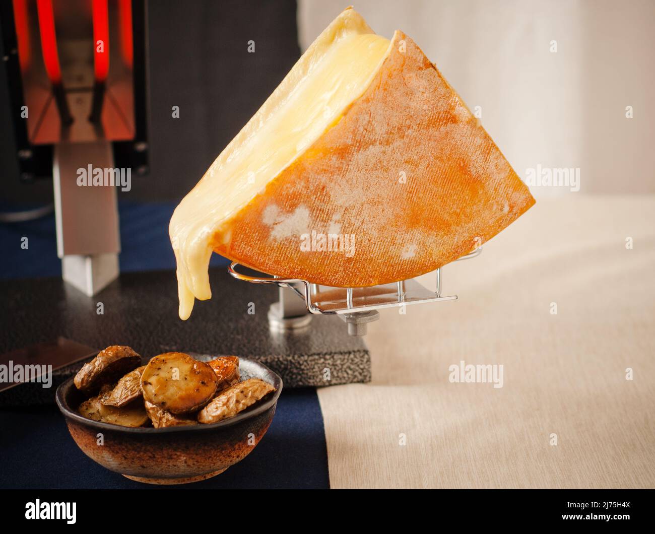 Raclette cheese with roasted potatoes Stock Photo - Alamy