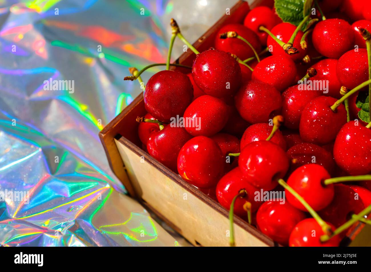 Defocus close-up cropped box, crape of dark red wet sweet cherries with ...