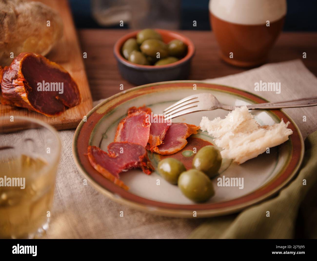 Jamon Iberico (dry cured ham) with green olives and bread Stock Photo ...