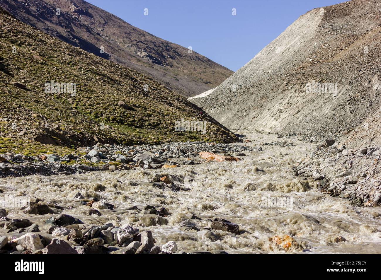 A rapid river flowing through the rocky slopes of a ravine on a ...