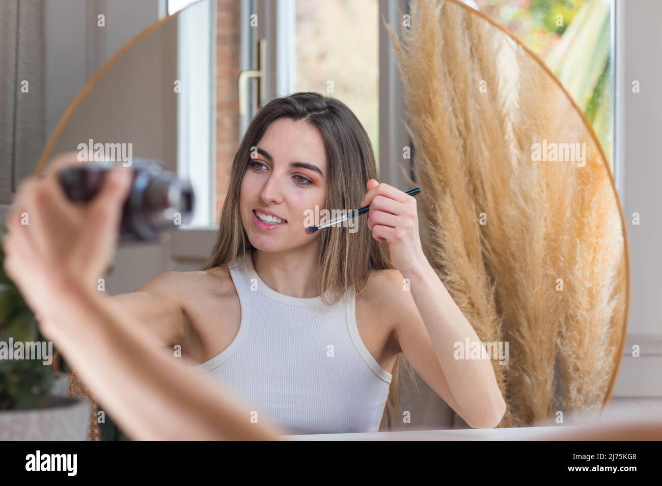 Beauty vlogger and influencer woman filming daily make-up routine ...