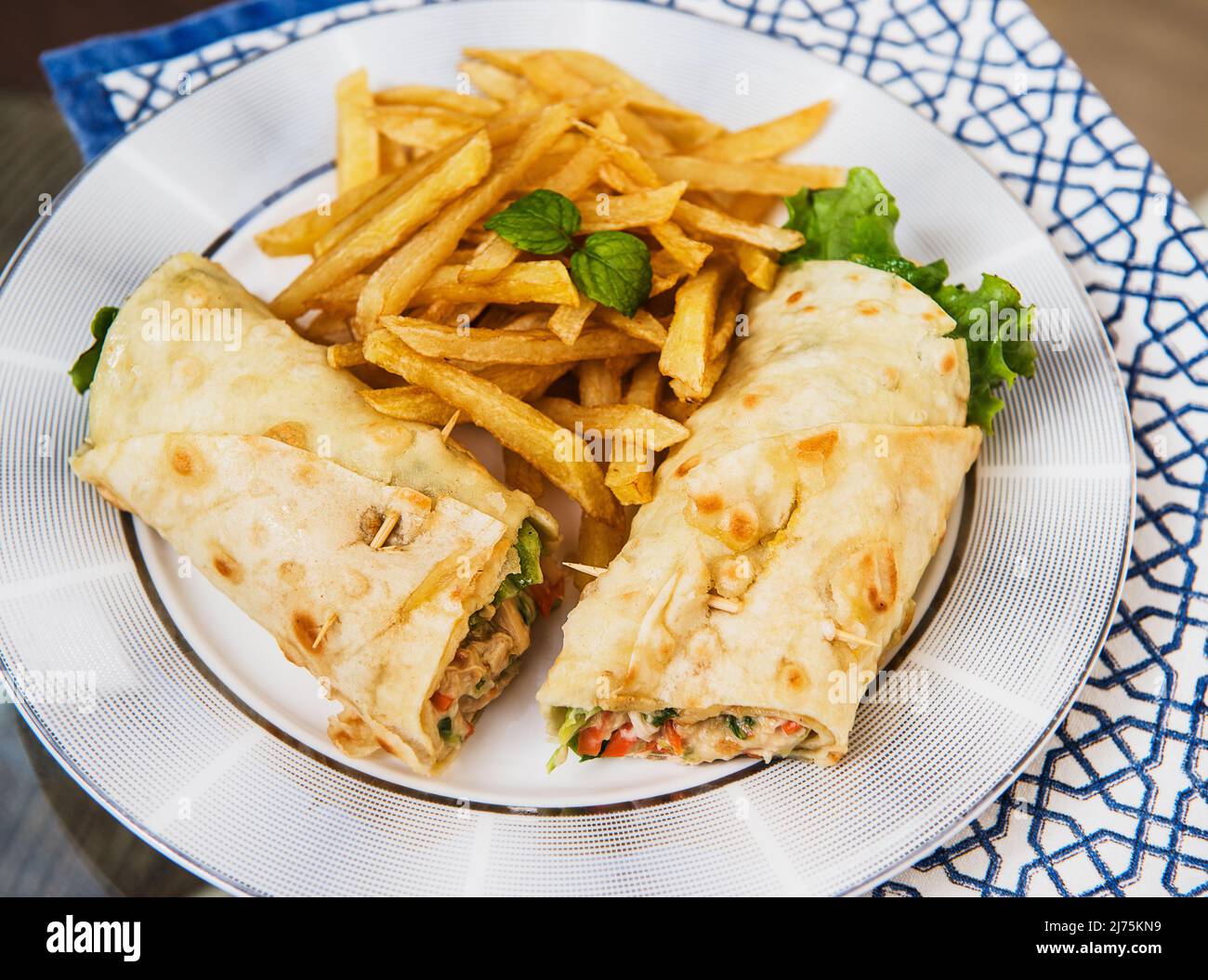 Chicken and vegetable wrap with French fries Stock Photo - Alamy