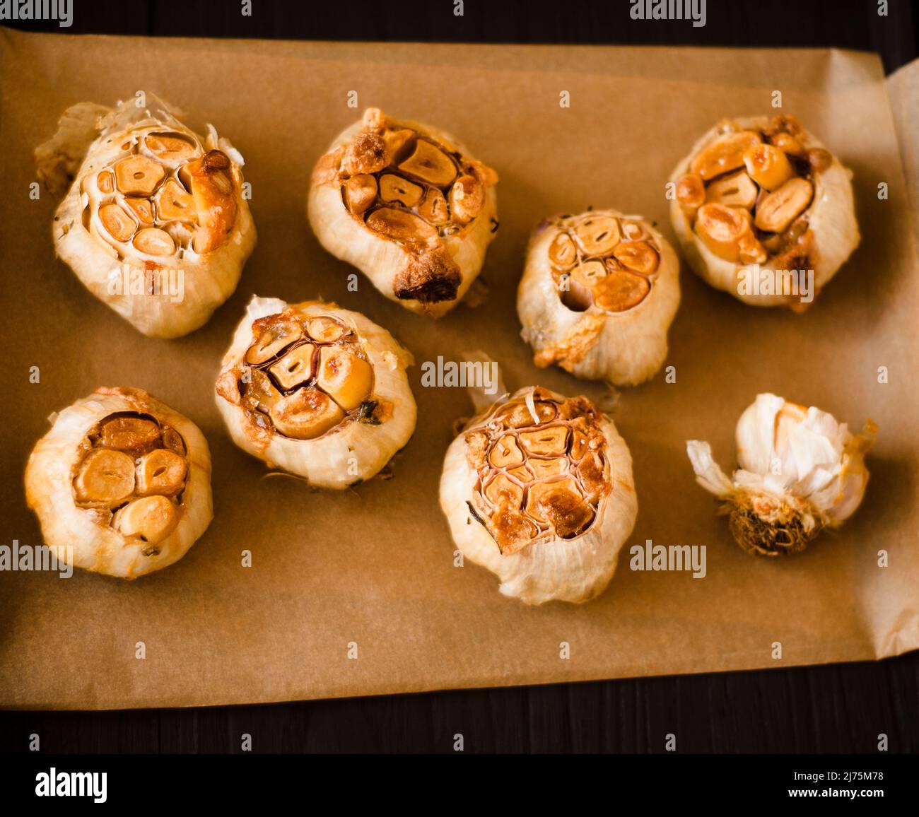 Roasted Garlic Bulbs on Parchment paper Stock Photo - Alamy
