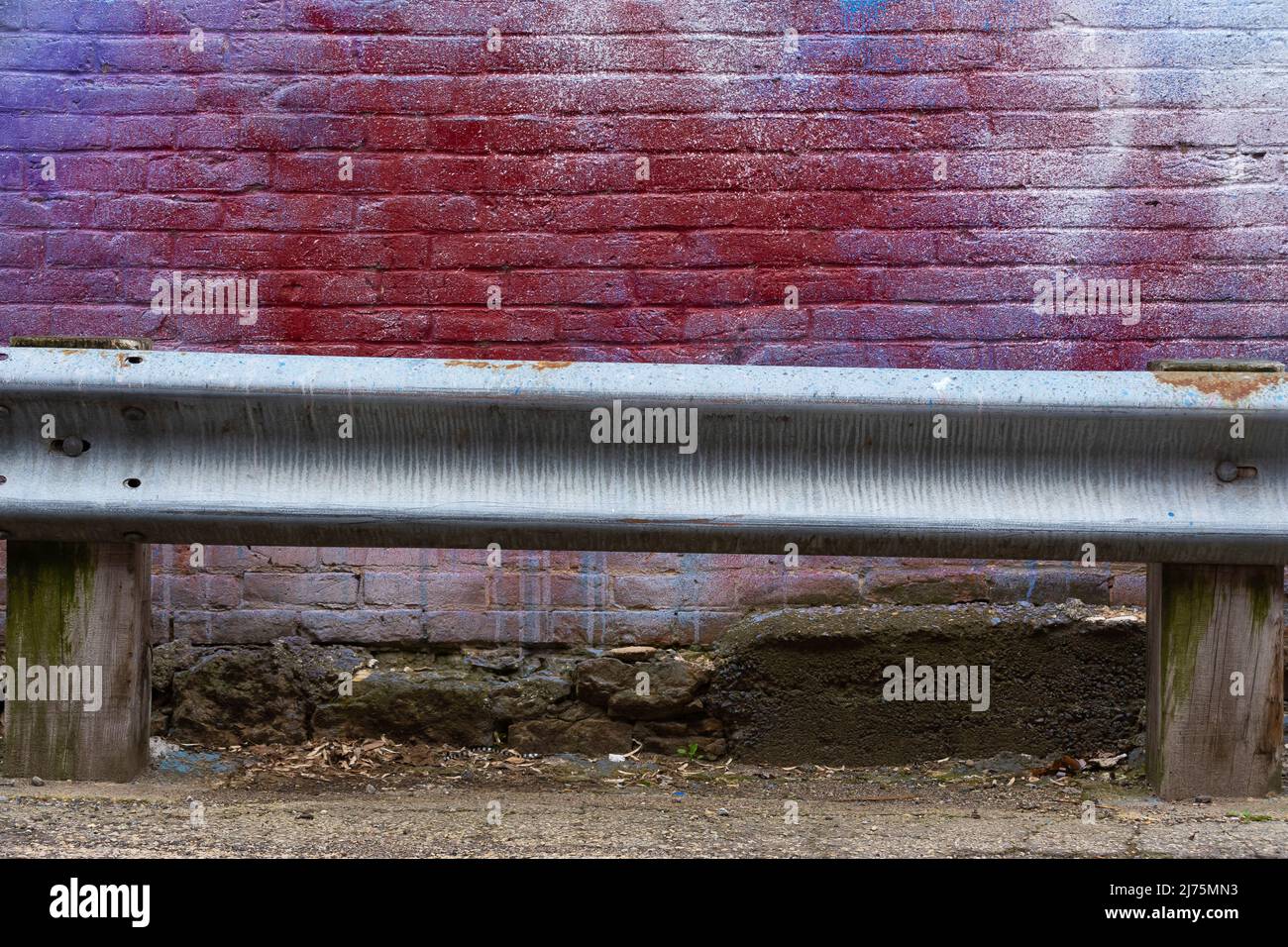 Painted brick wall and metal guard rail in Midwest city back alley ...
