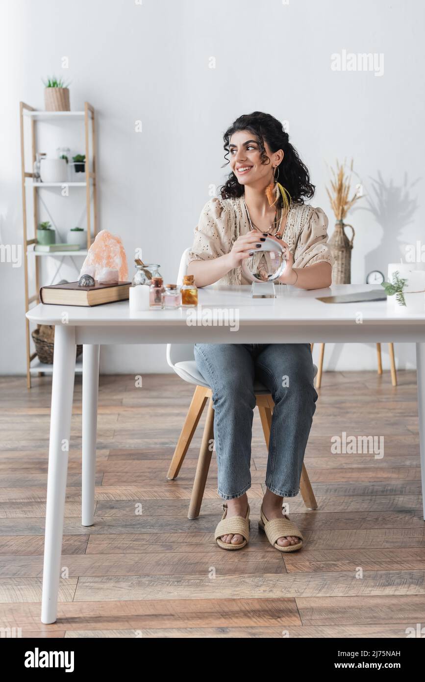 Positive gypsy medium touching orb near book and magic crystals on ...