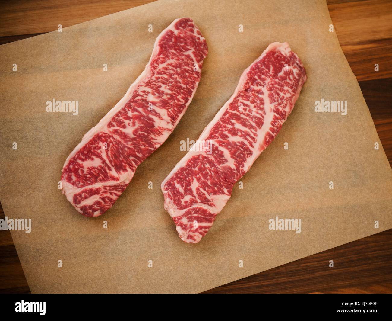 Two Raw Strip Steaks on Parchment Paper Stock Photo - Alamy
