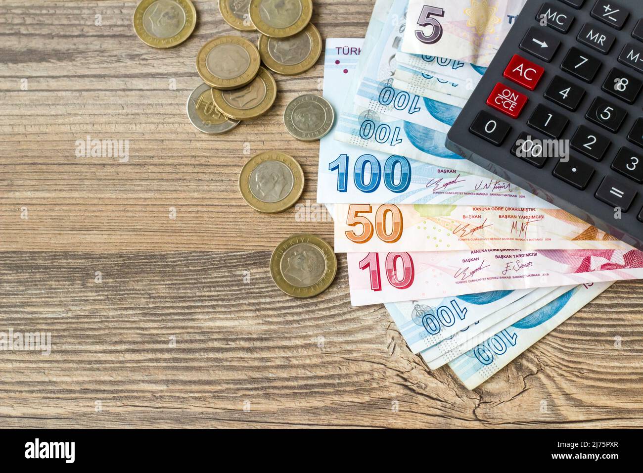 Turkish Lira Banknotes, coins and a calculator on the wooden surface ...