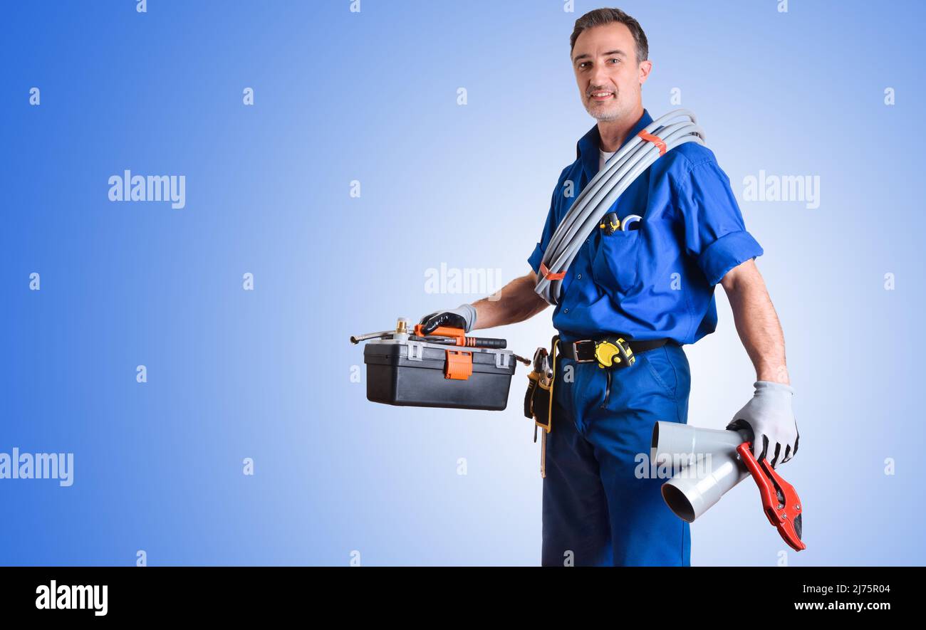 Portrait of uniformed plumber with work tools in hands and blue ...